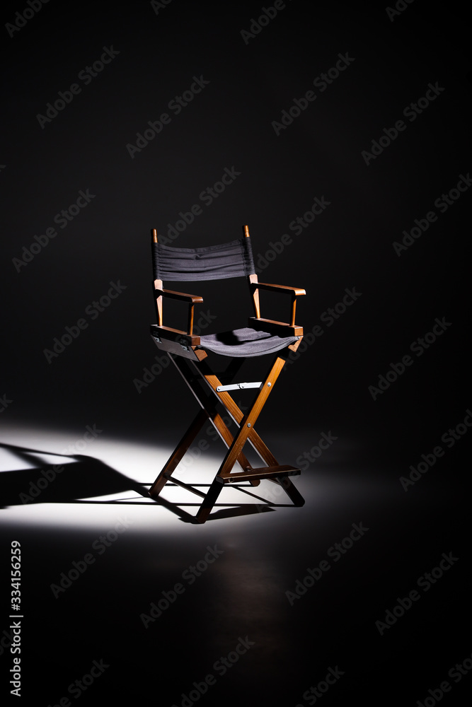 Directors chair stands in the beam of light. Space for text. Vacant ...