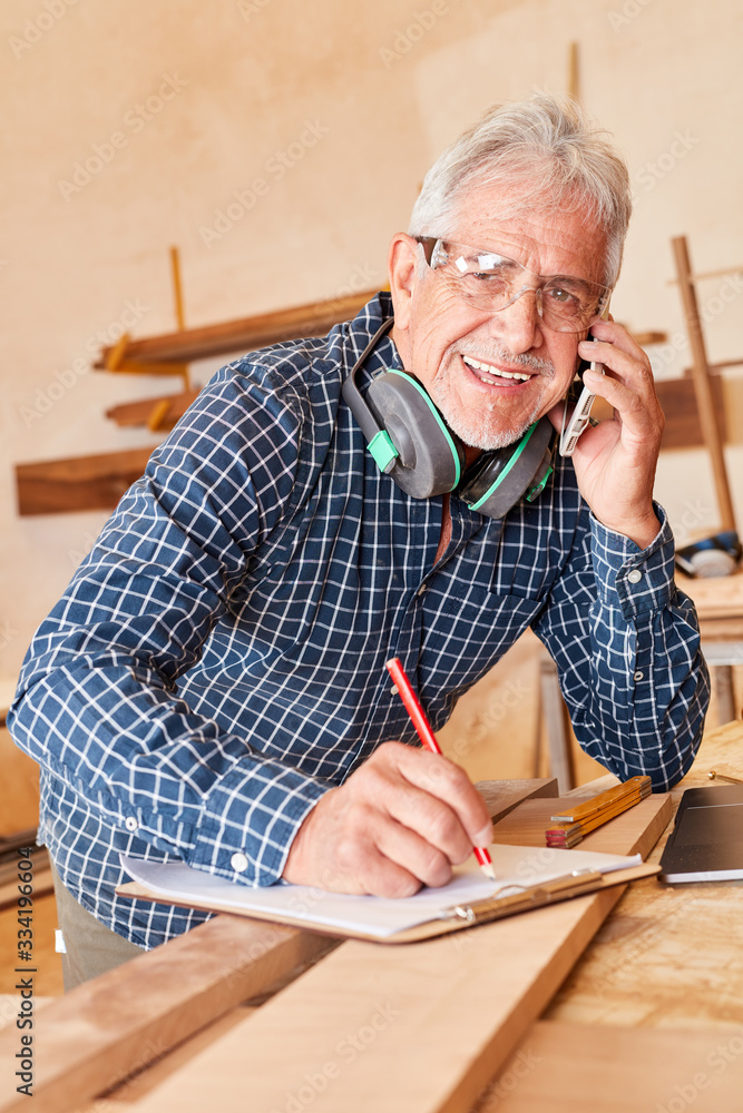 Craftsman with mobile phone notes appointments Stock Photo | Adobe Stock