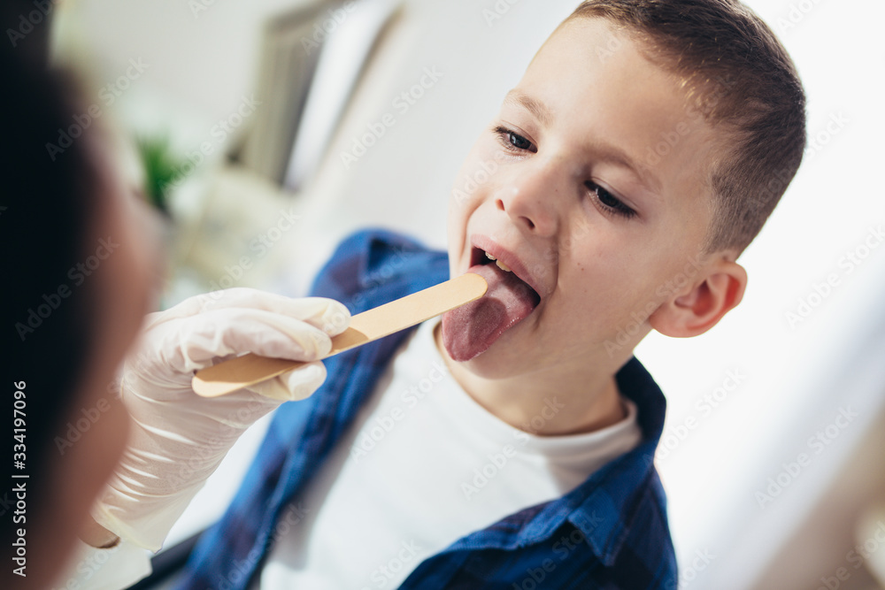 Pediatrician checks the throat of a boy. Tonsillitis, inflammation of ...