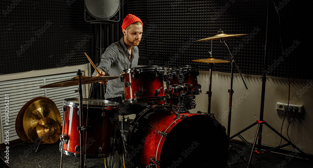 young caucasian drummer rehearsing on drums before rock concert ...