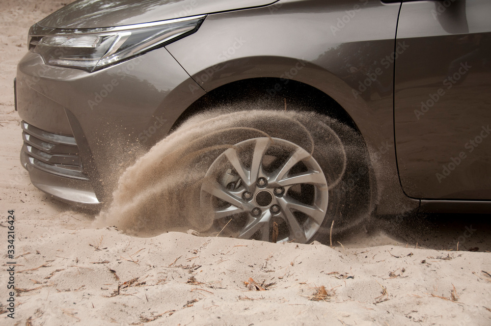 Car wheels on a sea beach sand. Close-up of car wheel on sandy dunes in ...