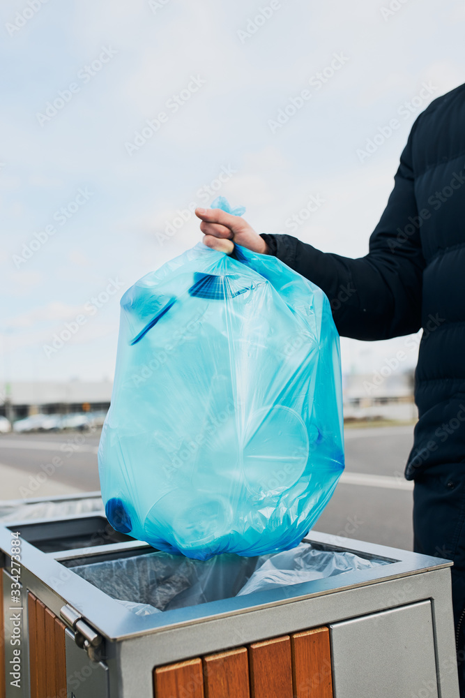 Man throwing a bag full of plastic waste to trash. Plastic waste to ...