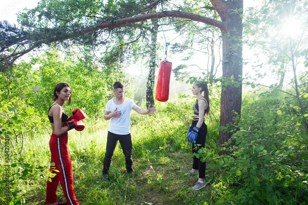 girls fighting boxing outside with coach in green park, sport summer ...