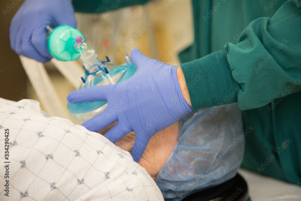 Oxygen mask ventilator is put on a patient prior to surgery anesthesia ...