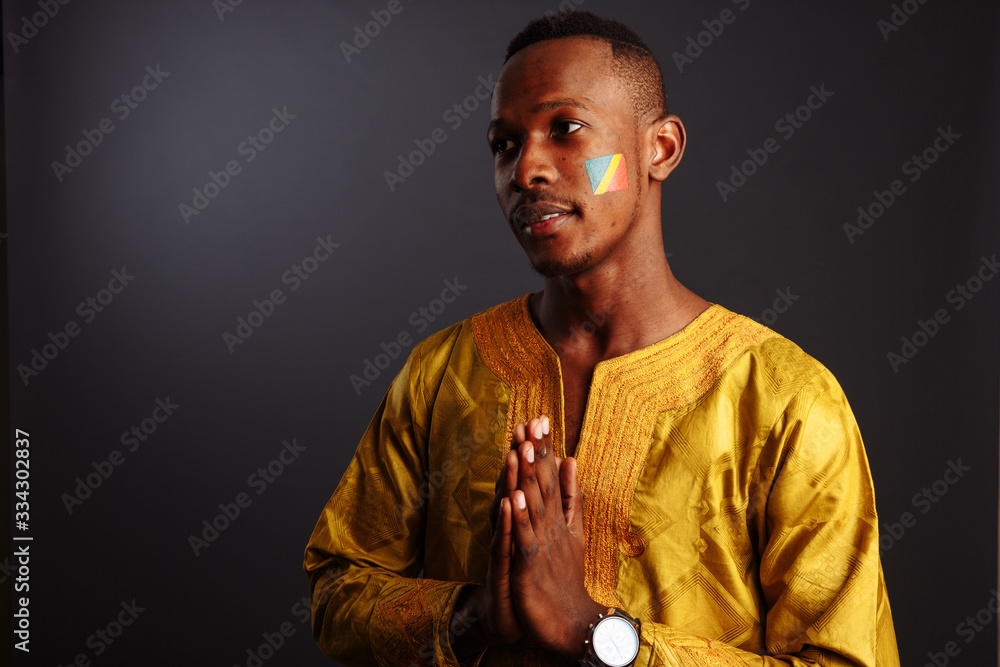 Friendly afro form Congo man in traditional clothes toothy praying, say ...