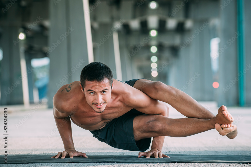 Man practicing advanced yoga pose. Arm balance, Eight Angle Pose or ...