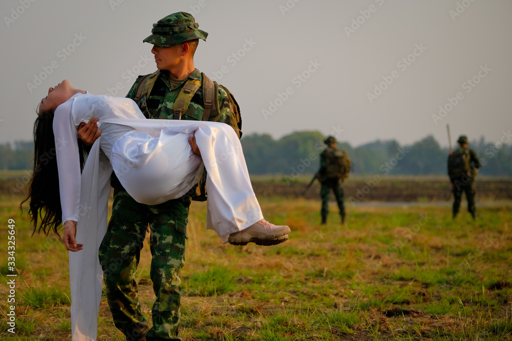 Soft blur of soldier man carry Vietnamese woman in the field also have ...