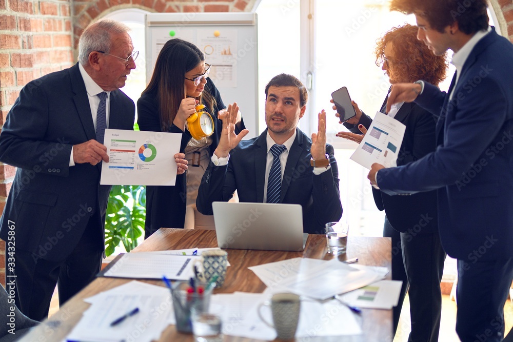 Group of business workers working together in a meeting. One of them ...