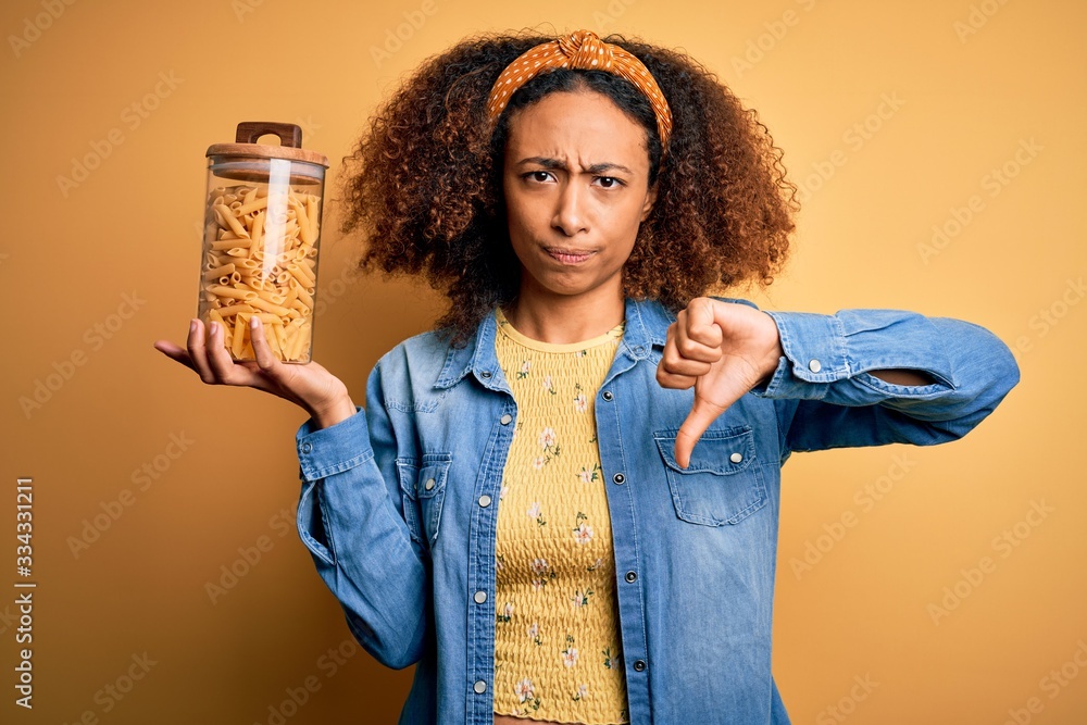 Young african american woman with afro hair holding jar with healthy ...