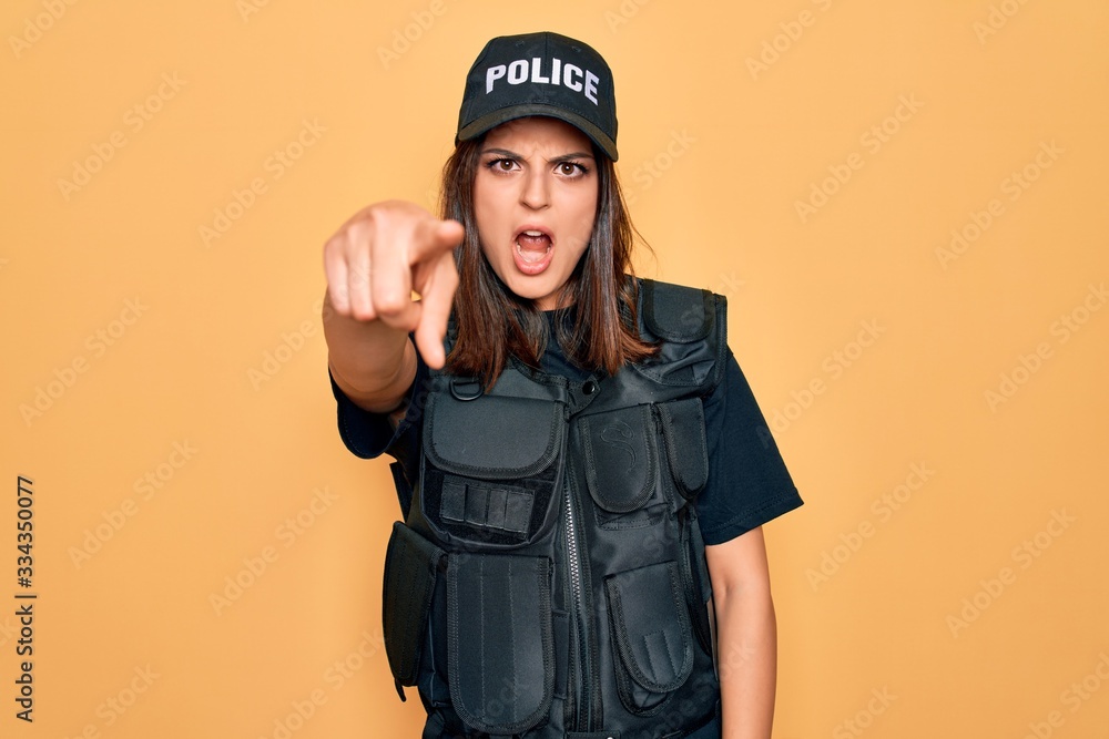 Young beautiful brunette policewoman wearing police uniform bulletproof ...