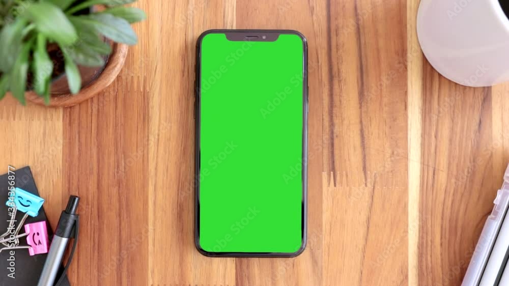 Smart phone place on table wood with green screen, Close-up the cell ...