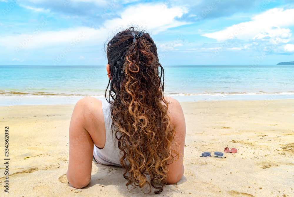 Back view pose of attractive female model enjoying her holidays at an ...