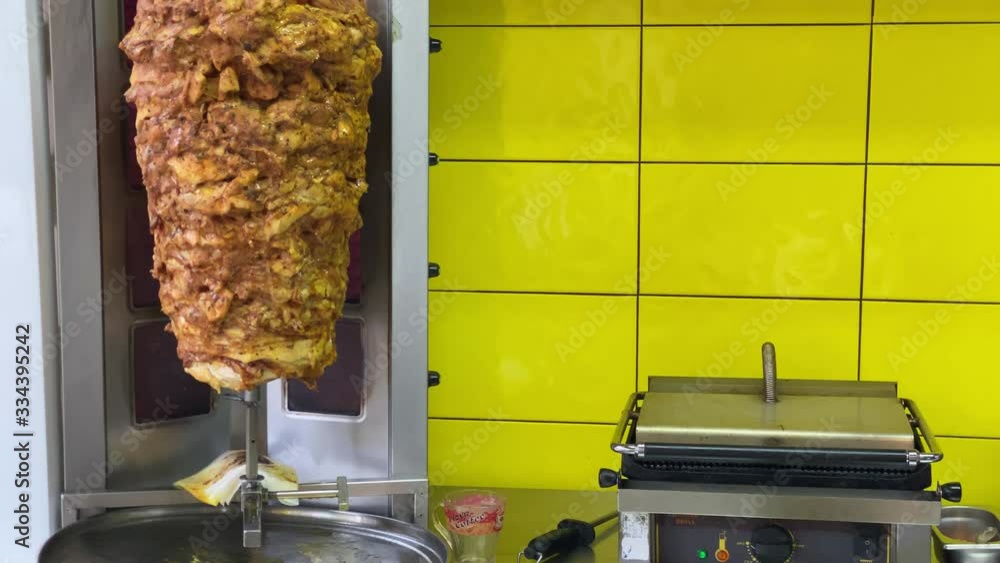 Skewered roasted chicken shawarma meat cooking and turning on rotating ...