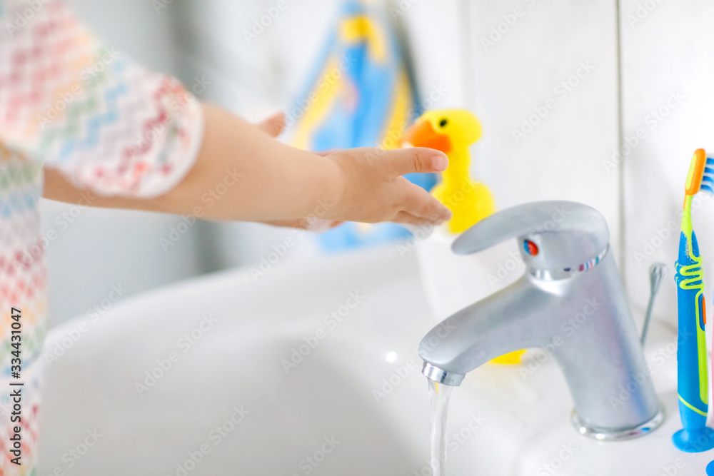Closeup of little toddler girl washing hands with soap and water in ...