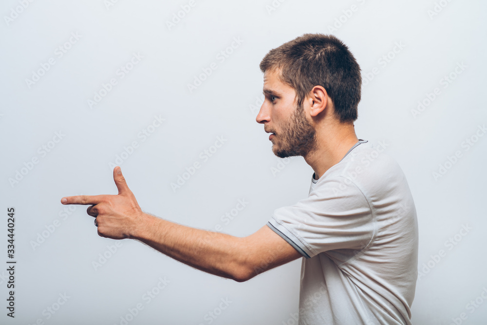 Closeup side view portrait of young man, pointing with finger at ...