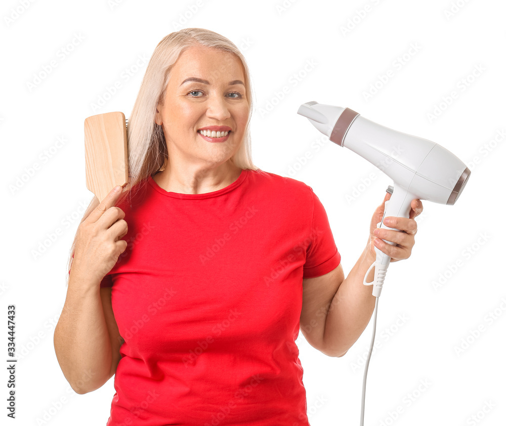 Beautiful mature woman with hair dryer on white background Stock Photo ...