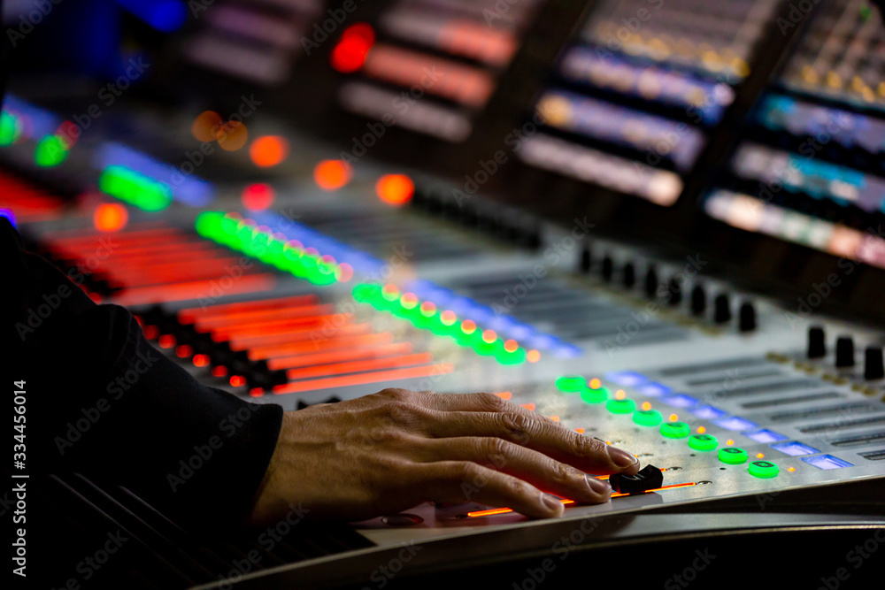 Sound engineer controls the settings on the mixing console panel in ...