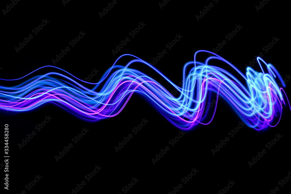 Long exposure photograph of neon blue and purple streaks of light in an ...