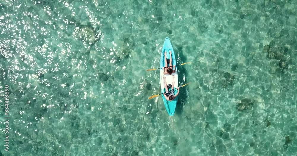 Top down aerial view shoot as couple paddle their blue white kayak in ...