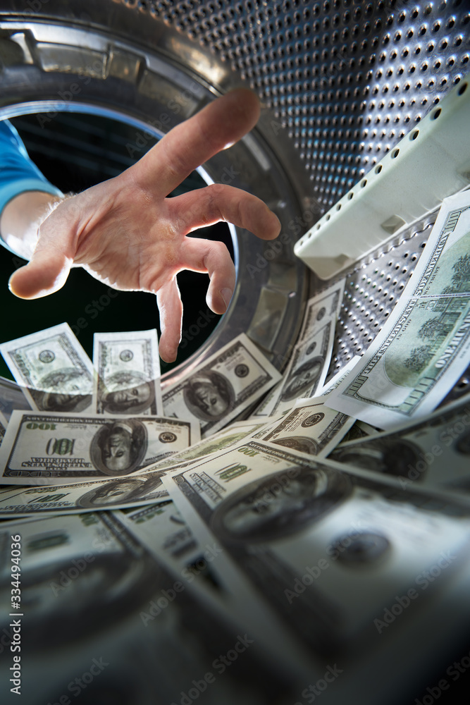 Criminal washing banknotes in machine, money laundering, financial ...