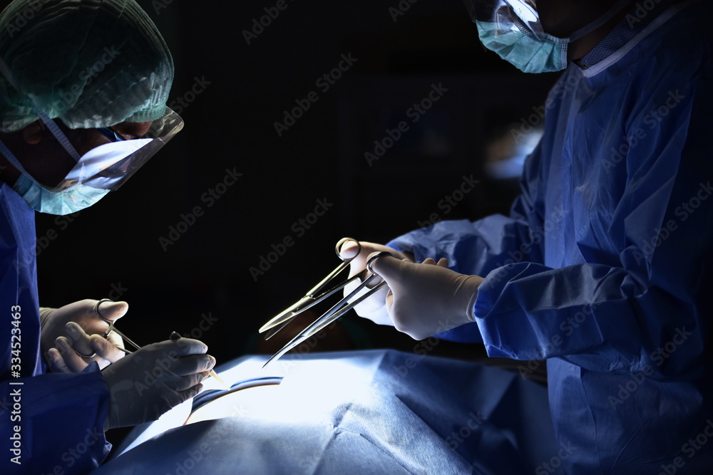surgical instrument lying on table while group of surgeon work in ...