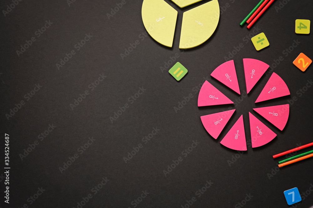 Mathematics background - fractions on black table, close up. Dividing ...