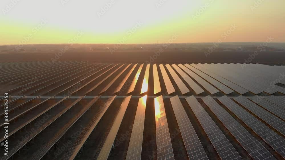 Aerial drone view into large solar panels at a solar farm at bright ...