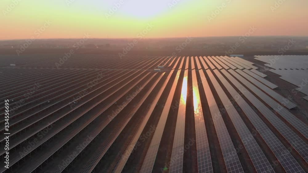 Aerial drone view into large solar panels at a solar farm at bright ...