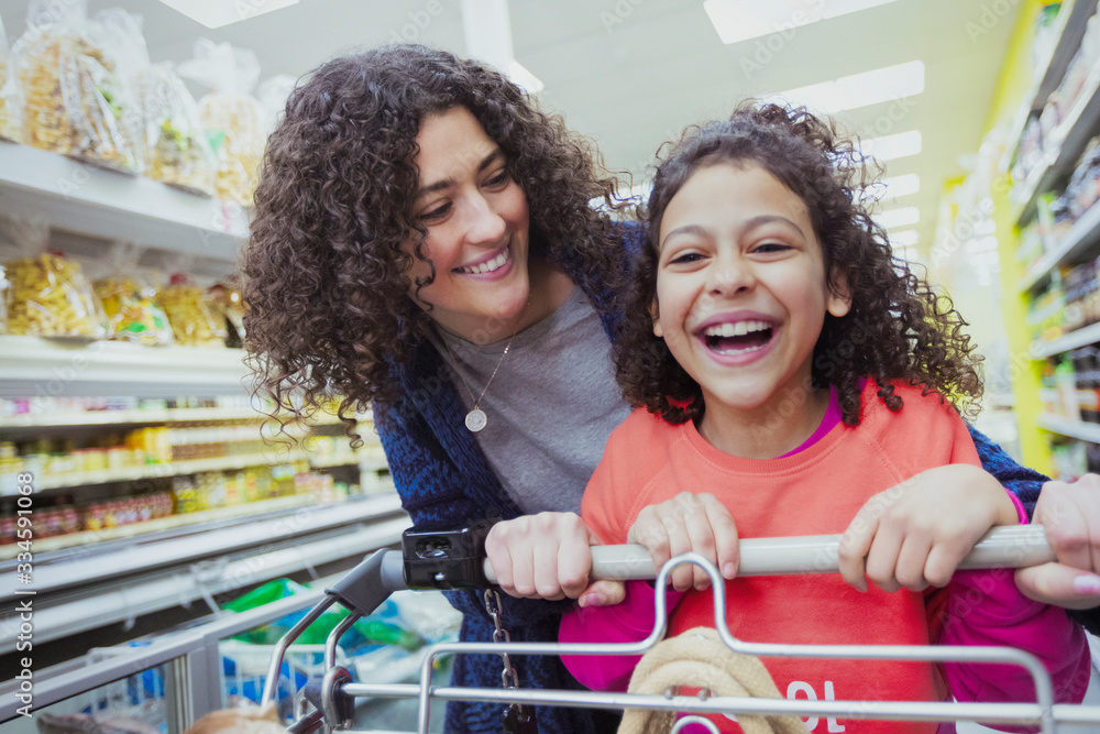Portrait happy mother and daughter shopping in supermarket Stock Photo ...
