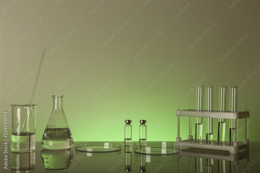 conceptual background with chemical flasks. green backdrop with lab ...