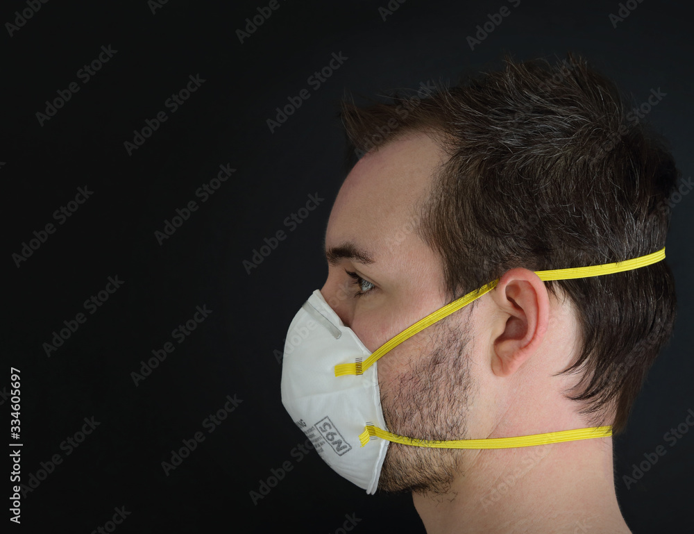 A man is shown wearing a protective N95 white respirator dusk mask from ...
