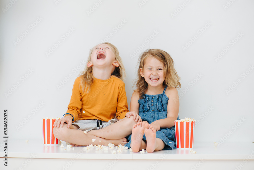 Two nauty children threw popcorn all around and laughing Stock Photo ...