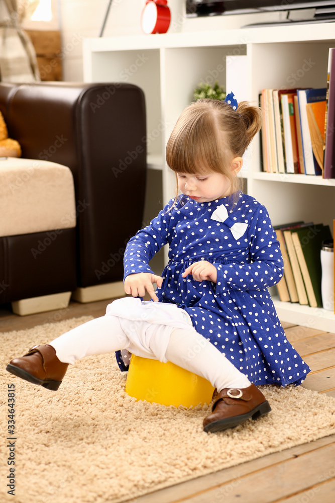 Cute little girl sit on her chamber pot do caca playing with cellphone ...