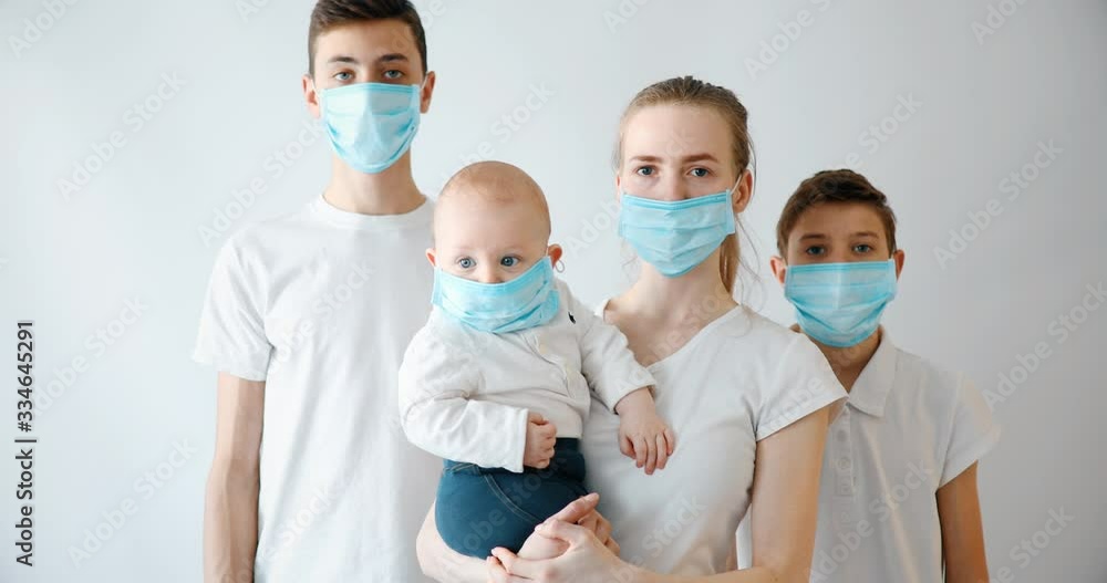 Family parents and children wear medical masks to prevent infection ...