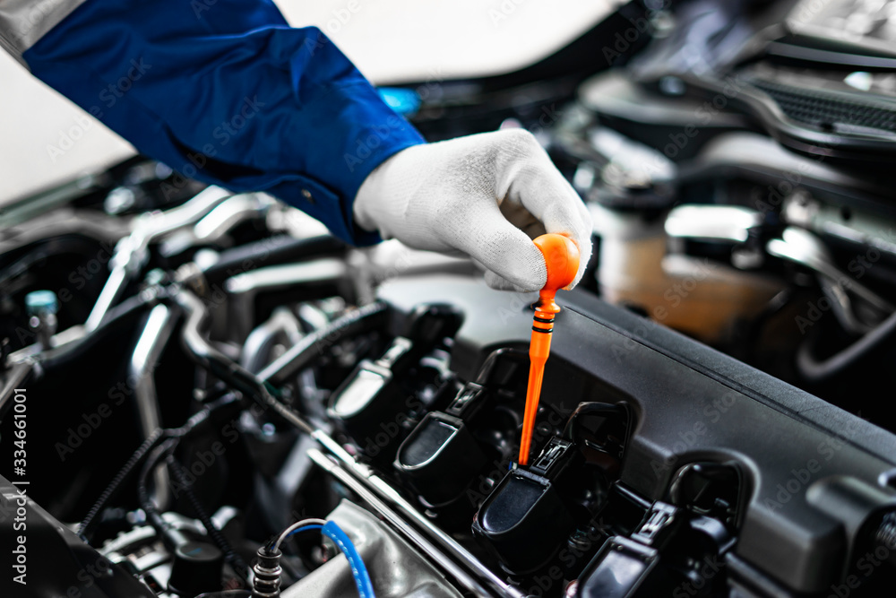 concept of male asian car mechanic holding siphon tube oiling on the ...