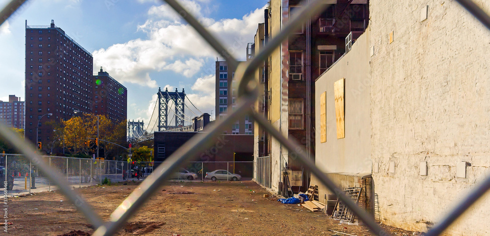 Vacant lot and Manhattan Bridge behind wire mesh in Manhattan in New ...