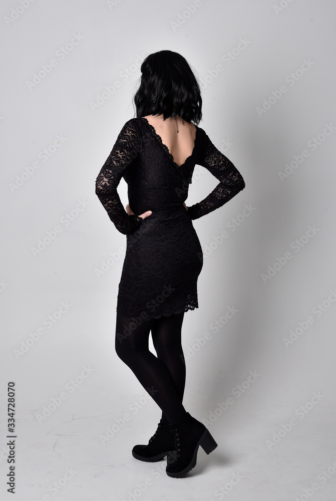 Portrait of a goth girl with dark hair wearing black lace dress and ...