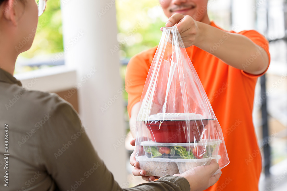 Delivery man giving lunch box meal in the bag to customer that ordered ...