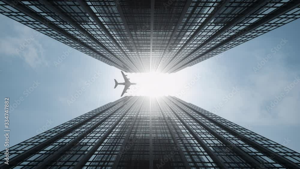 Airplane flies between high rise buildings crossing sun flare and ...