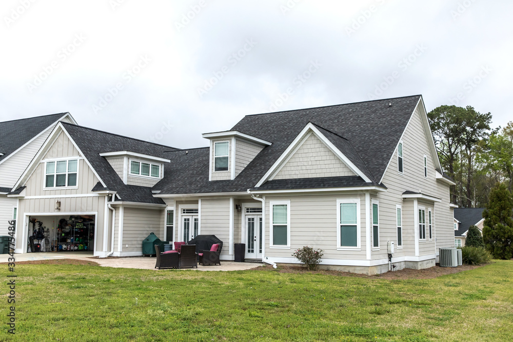 The back rear view of a new construction home with a covered up ...