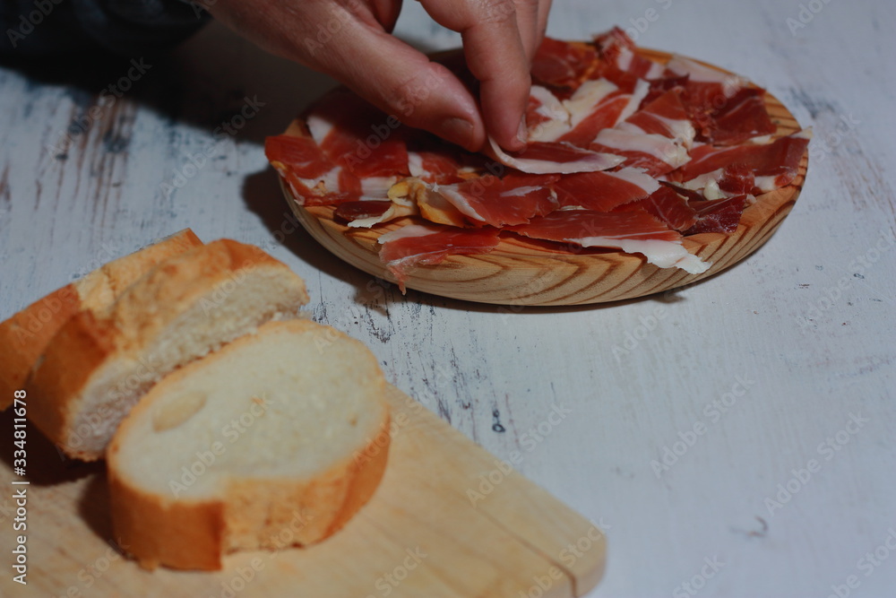 Jamón serrano o Jamón ibérico sobre un plato de madera, acompañado de ...