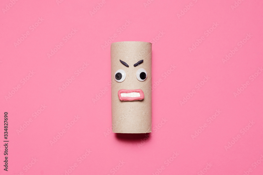 Empty angry toilet paper roll with googly eyes and mouth on a pink ...