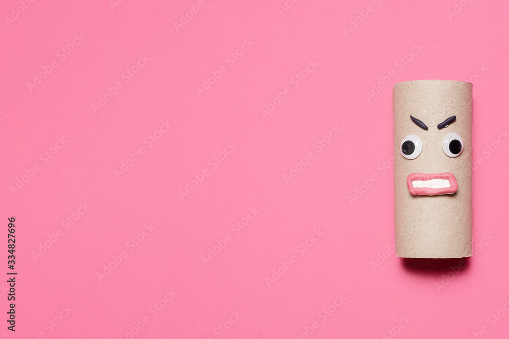 Empty angry toilet paper roll with googly eyes and mouth on a pink ...