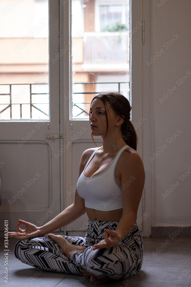 View of young beautiful woman doing morning yoga after waking up at ...