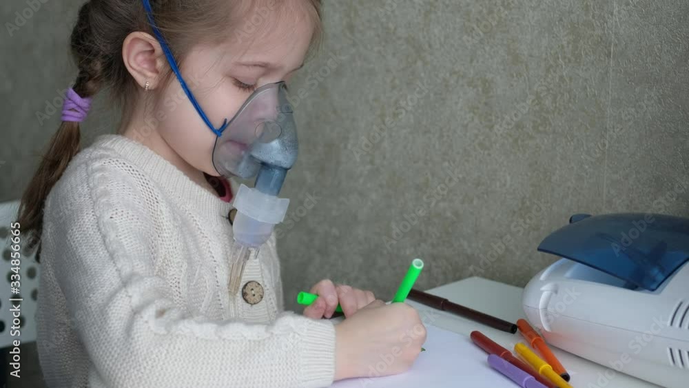 Little girl makes an inhalation vapor and draws a drawing. Child is ...