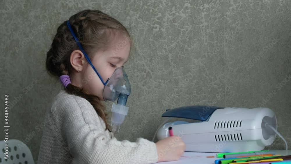 Little girl makes an inhalation vapor and draws a drawing. Child is ...