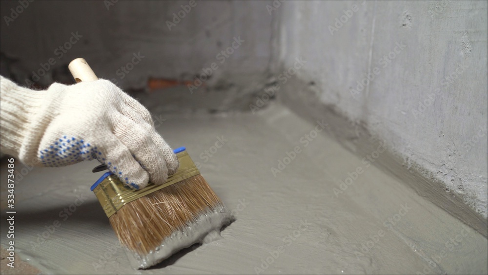 The process of applying mortar - waterproofing to a concrete floor. The ...