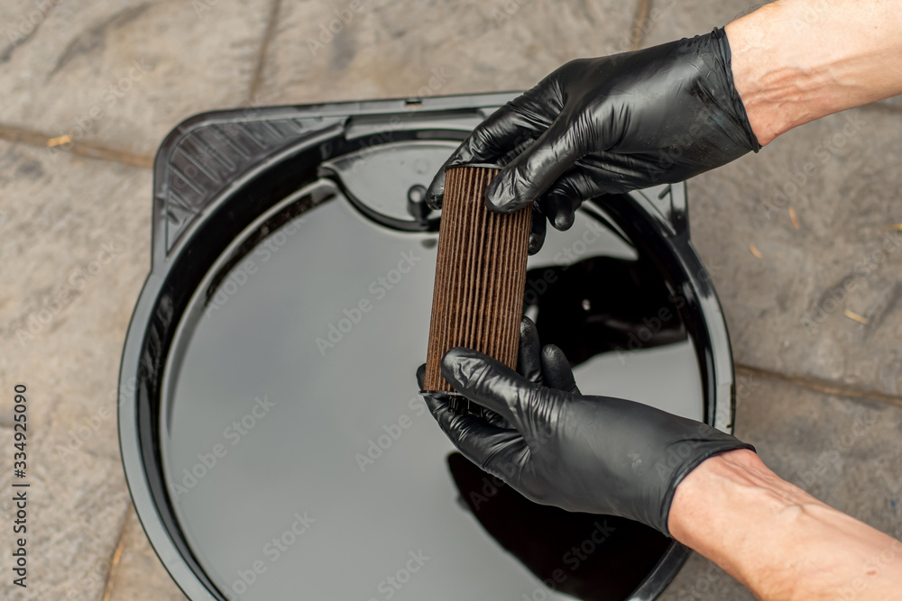 Used drained motor oil in a black tray and used oil filter. DIY change ...