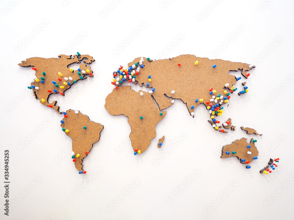 Colorful pushpin for marking location at wooden world map on the wall ...