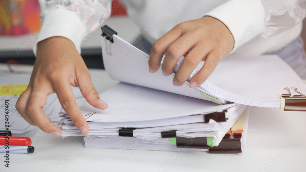 Businesswoman hands working in stacks of paperwork files for searching ...